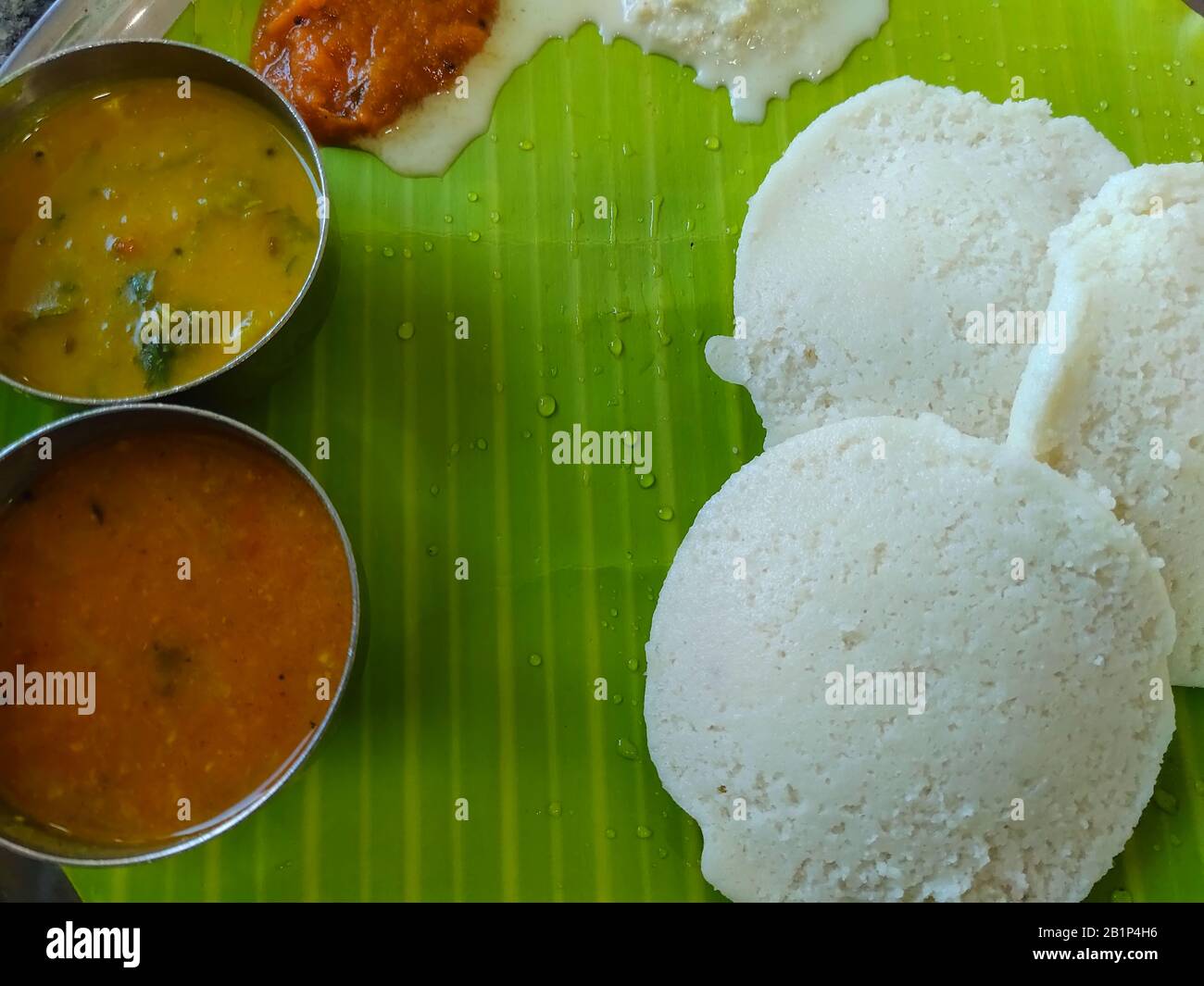 south indian food or dish ( idly with side dish ) on banana leaf, close ...