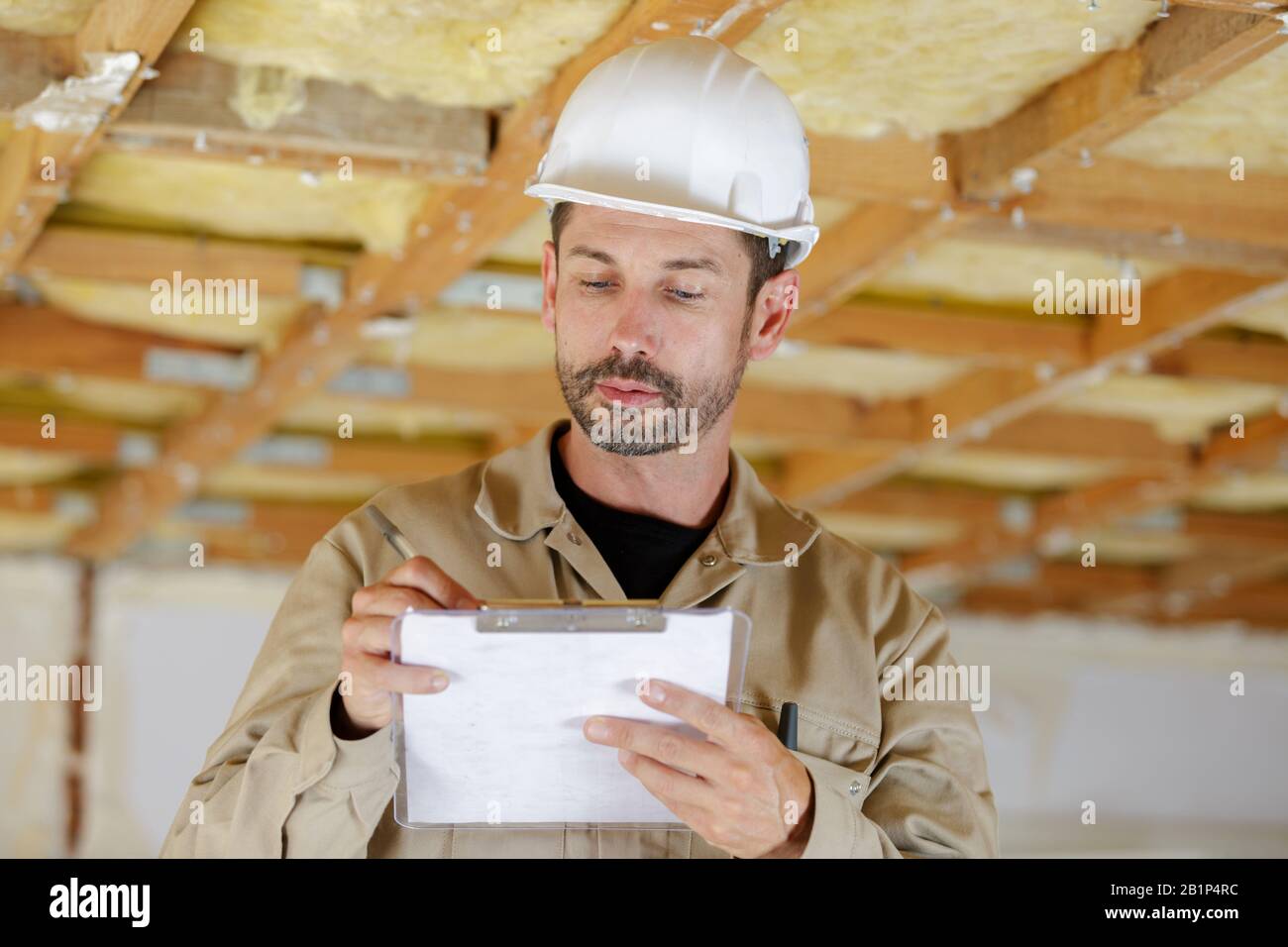 a builder using a clipboard Stock Photo - Alamy