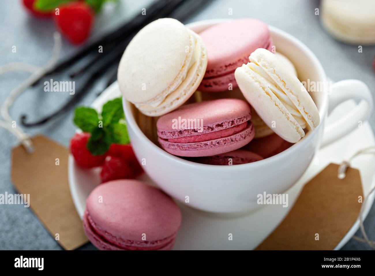 Vanilla and raspberry macarons in a teacup Stock Photo - Alamy