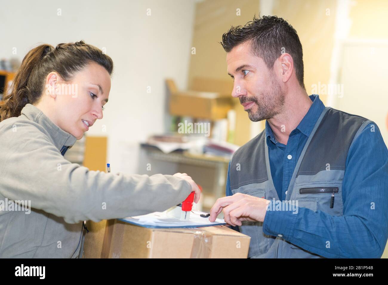 female worker using stamp to sign delivery drivers paperwork Stock ...