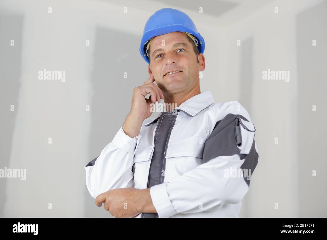 portrait of builder man standing indoors Stock Photo - Alamy