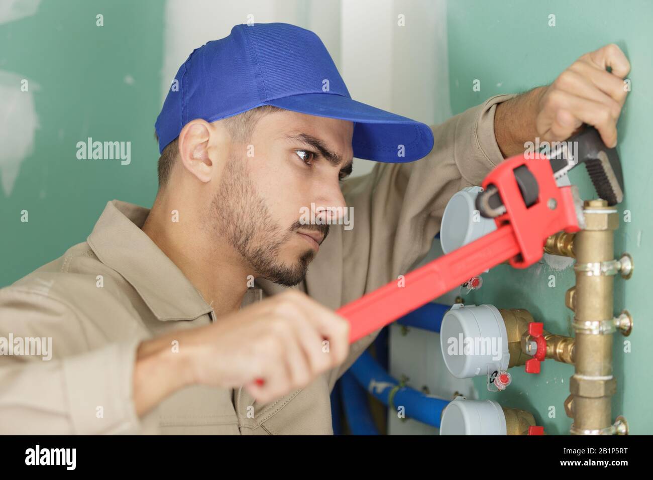 male plumber fixing water meter with adjustable wrench Stock Photo - Alamy