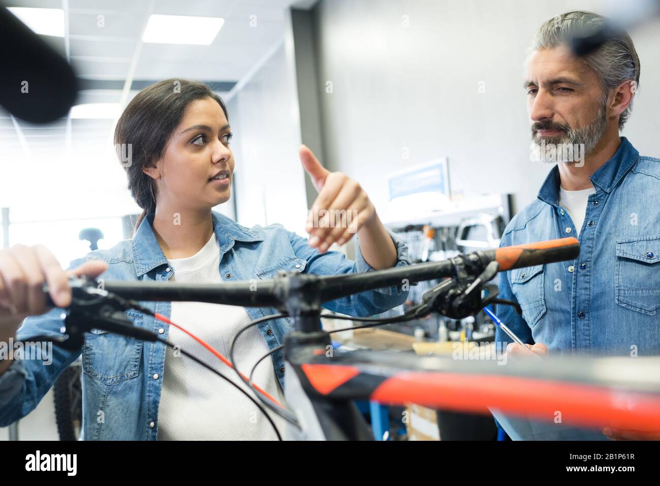 female customer enquiring about bicycle in store Stock Photo - Alamy