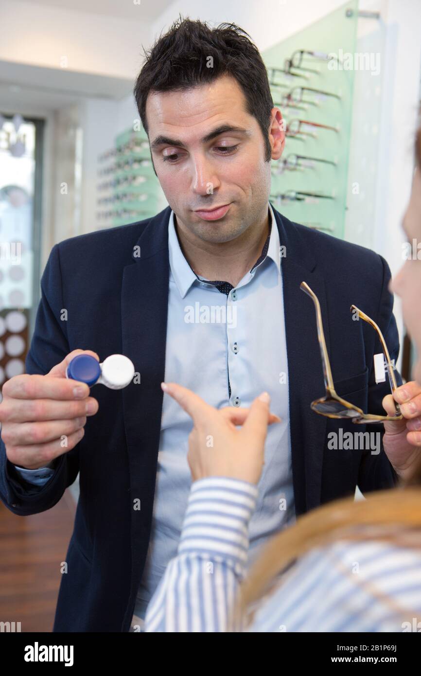 handsome man choosing between eyeglasses and lens Stock Photo - Alamy