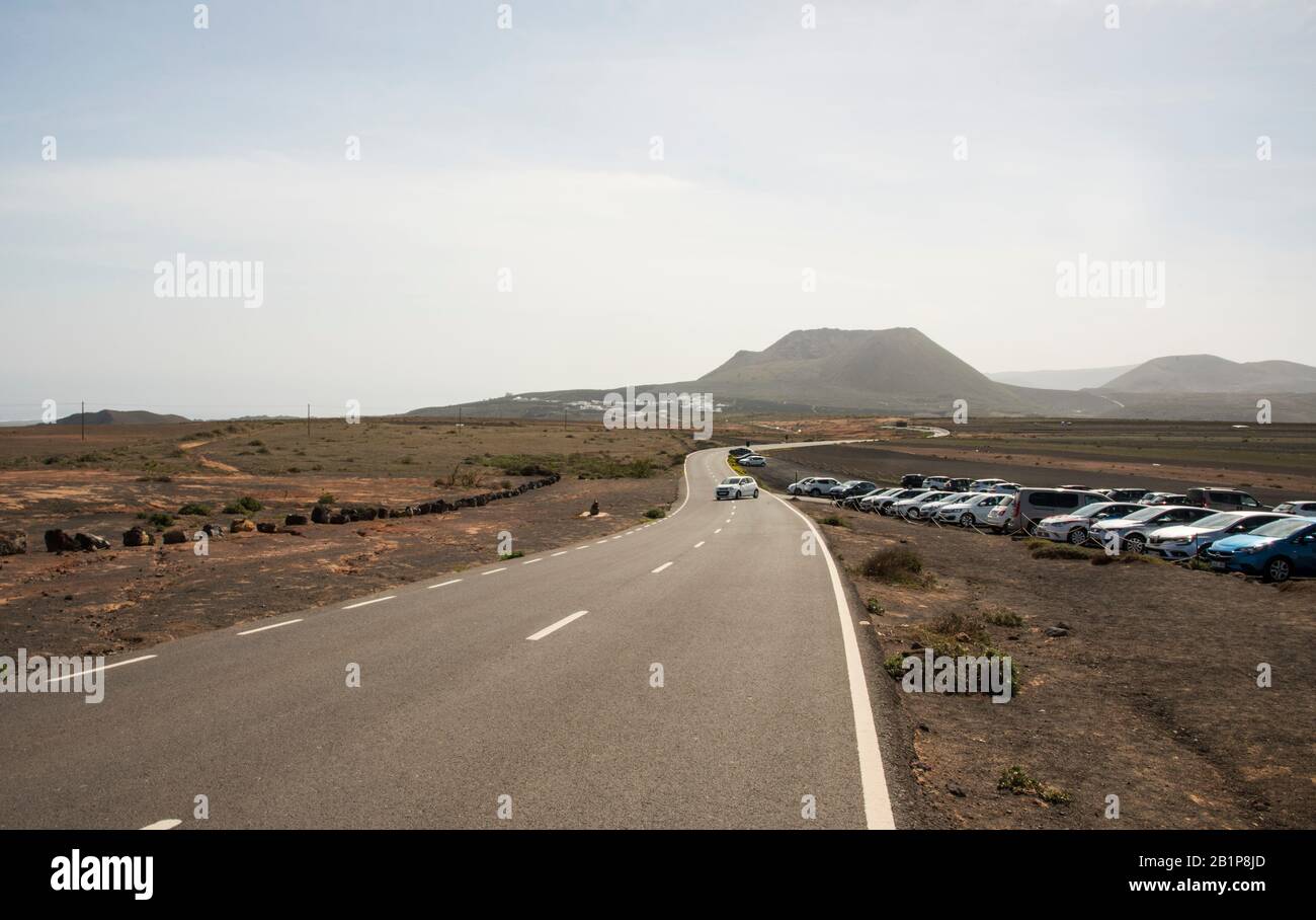 Tourists cars parked along an open road showing the landscape of ...