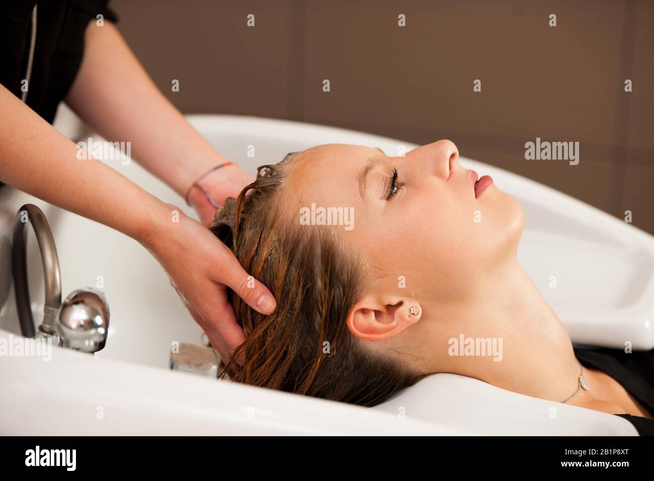 Hair stylist at work - hairdresser washing hair to the customer before ...