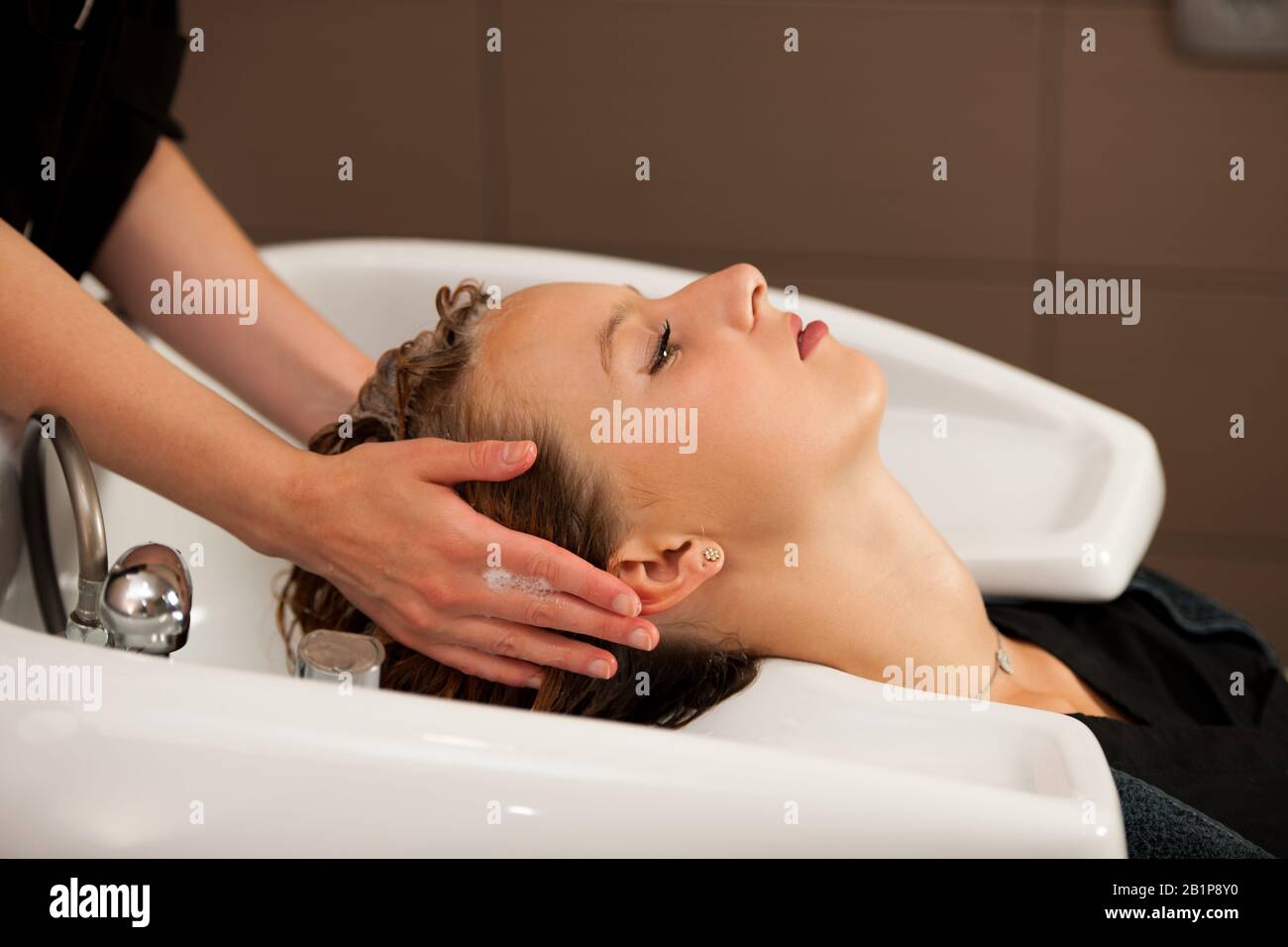 Hair stylist at work - hairdresser washing hair to the customer before ...