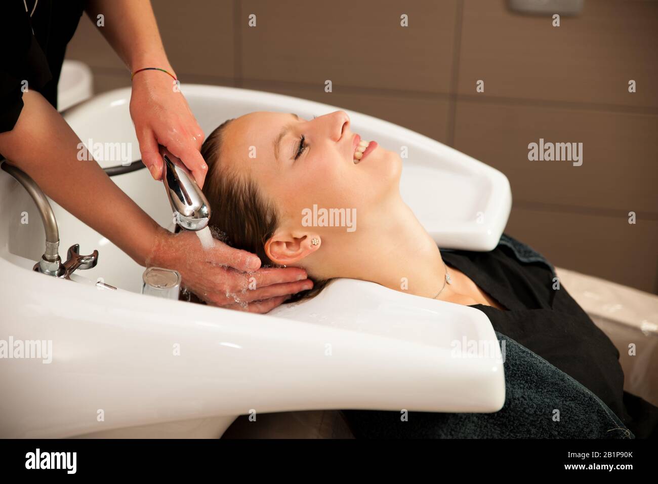 Hair stylist at work - hairdresser washing hair to the customer before ...