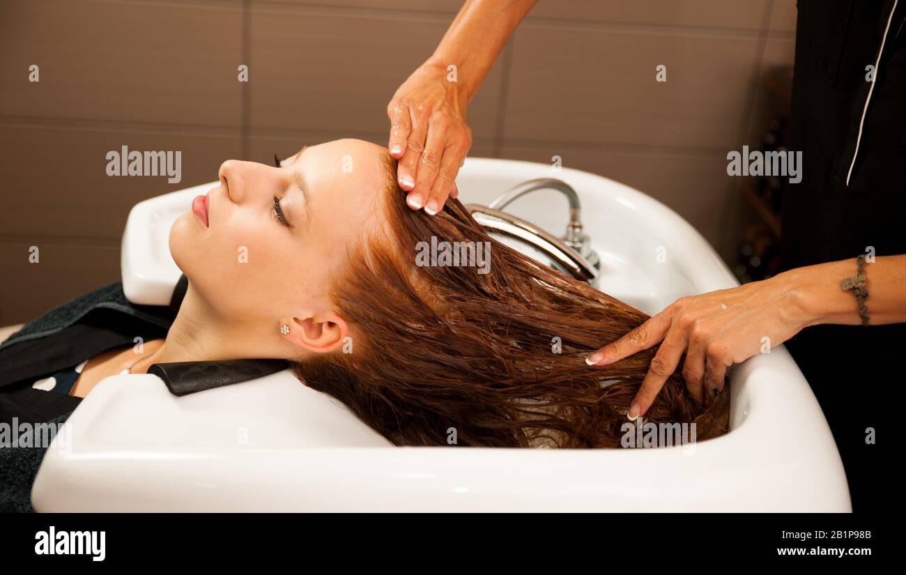 Hair stylist at work - hairdresser washing hair to the customer before ...
