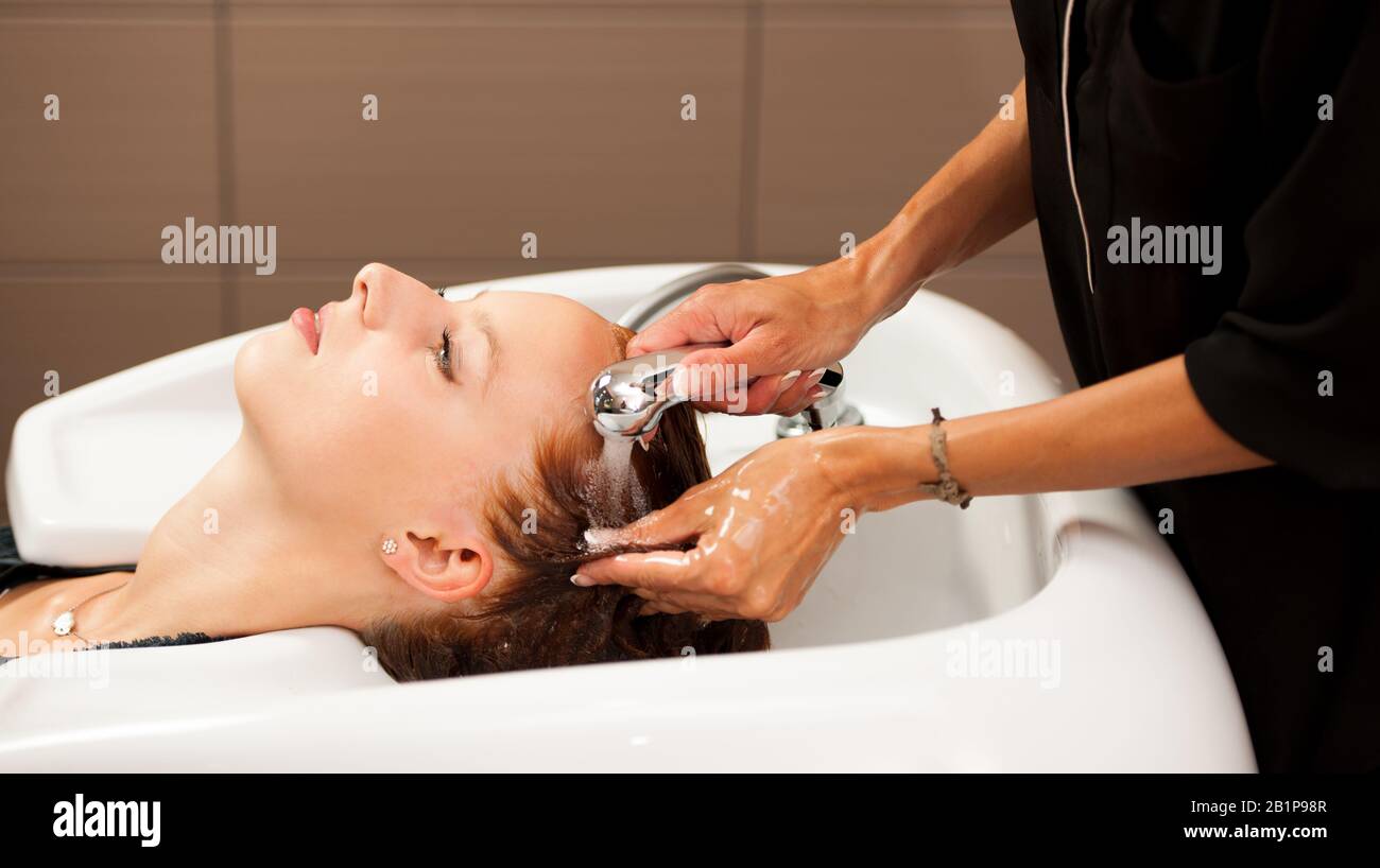 Hair stylist at work - hairdresser washing hair to the customer before ...