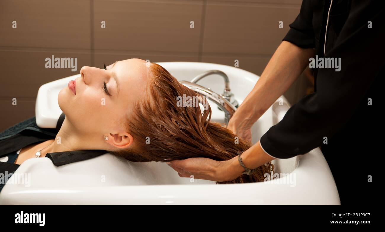 Hair stylist at work - hairdresser washing hair to the customer before ...