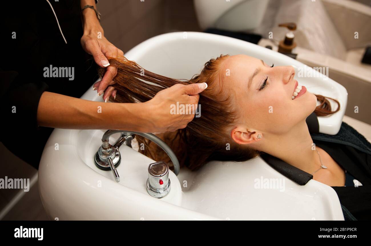 Hair stylist at work - hairdresser washing hair to the customer before ...