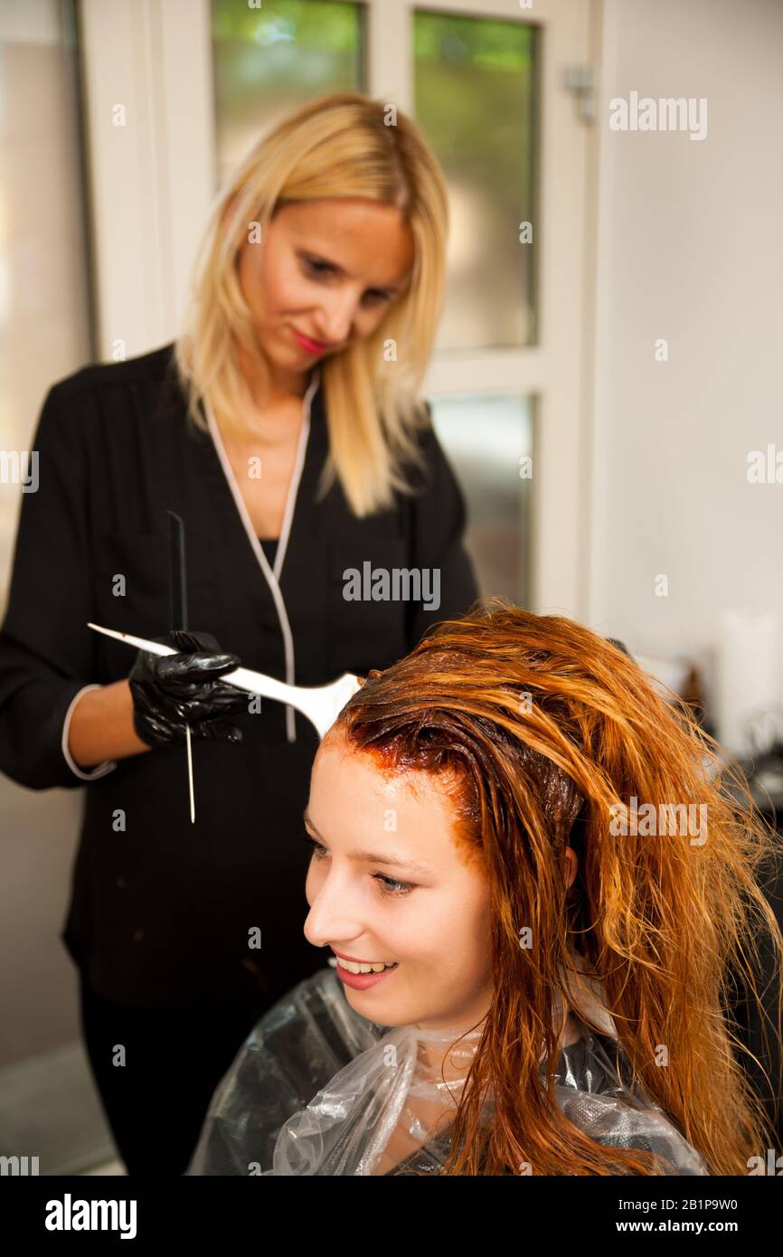 Hair stylist at work - hairdresser applying color on lonh hair Stock ...