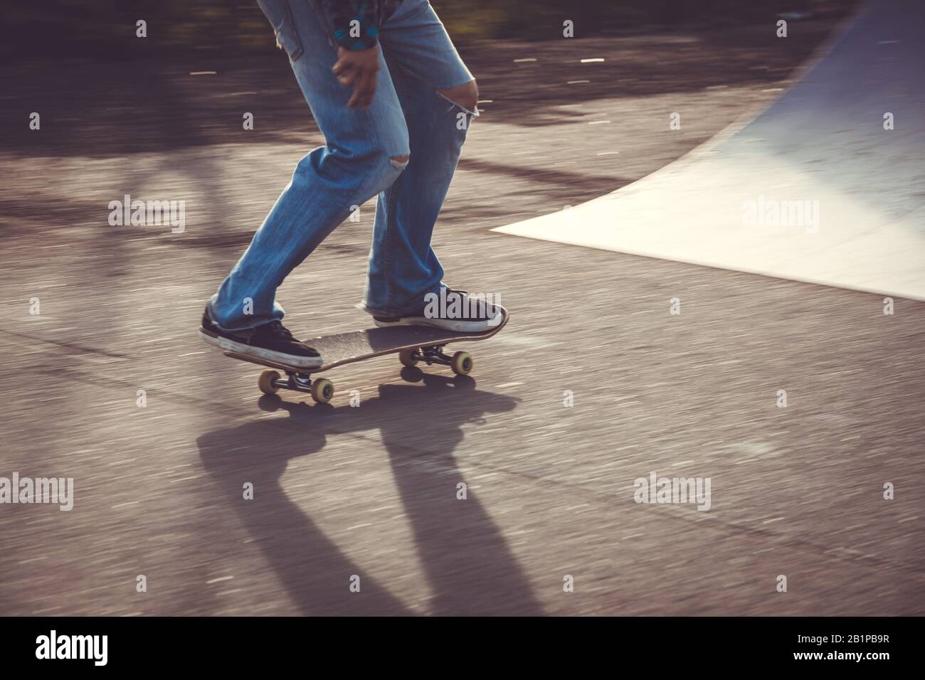 Skateboarder riding fast towards the ramps to be lifted into the air ...