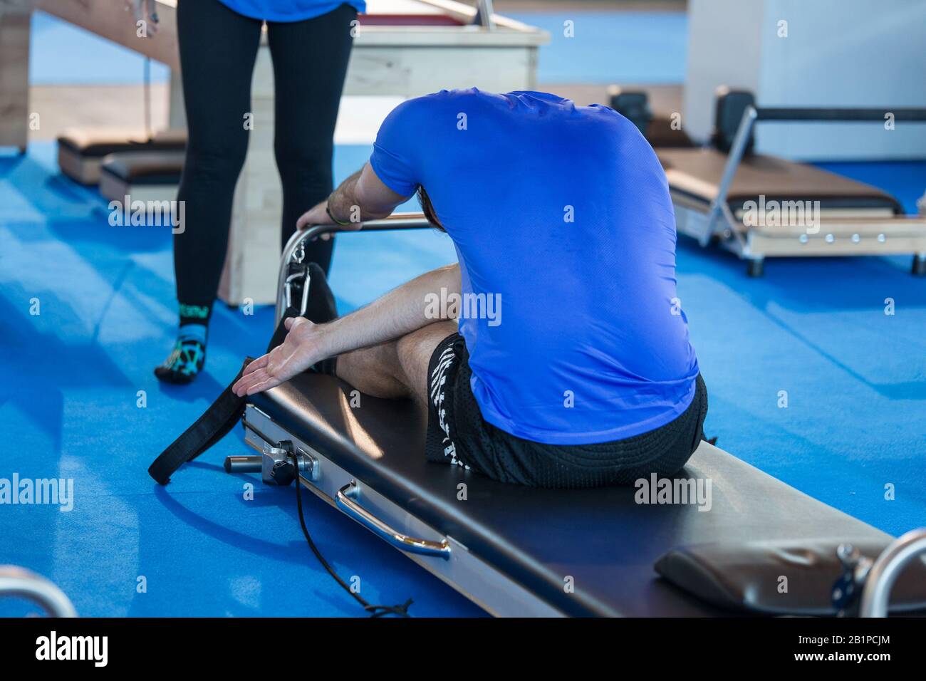 Boy sitting with his Legs Outstretched doing Stretching Before Fitness ...