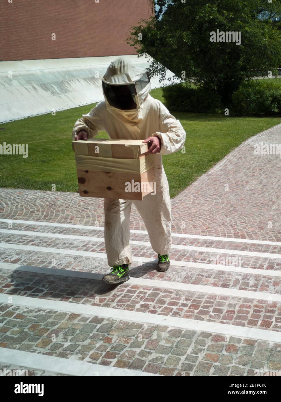 Beekeeper with Overalls and Protective Suit with a Box full of ...