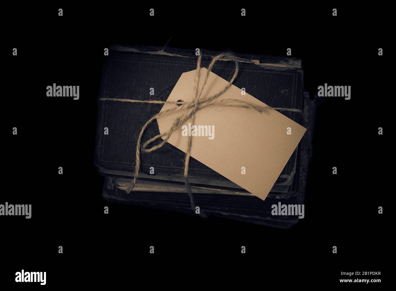 Antique old books stacked into a pile tied with string with a label ...
