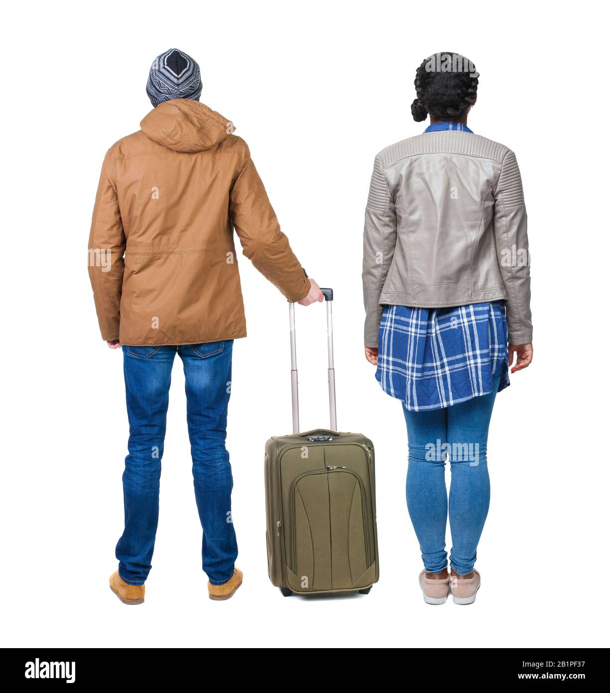 young couple in winter jacket traveling with suitcas. Back view. Rear ...