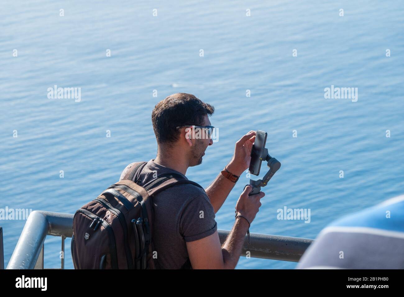 Man in 20's using a mobile camera on a gimble to video scenery by the ...