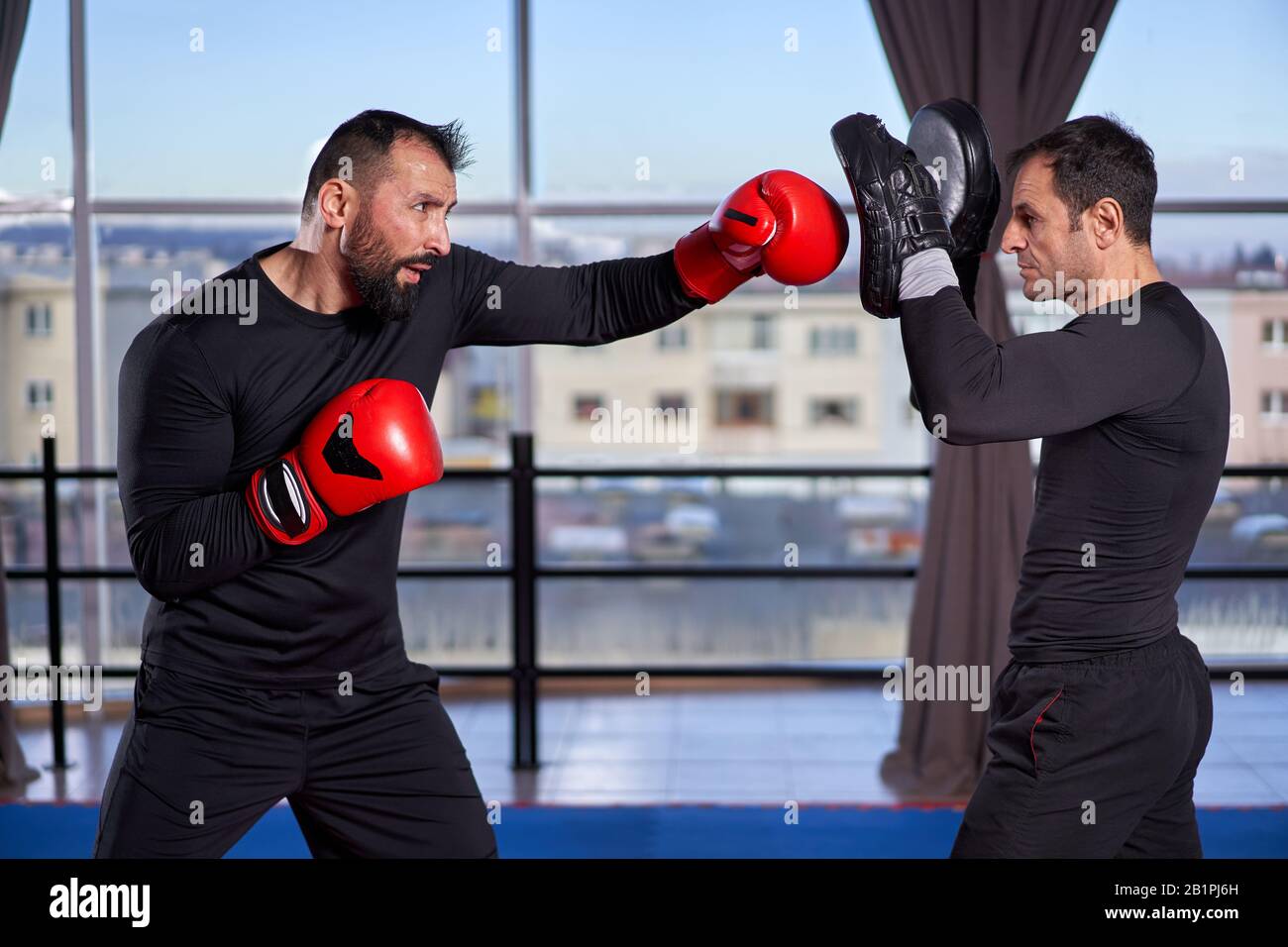 Kickboxer hitting pads with his coach in the gym Stock Photo - Alamy