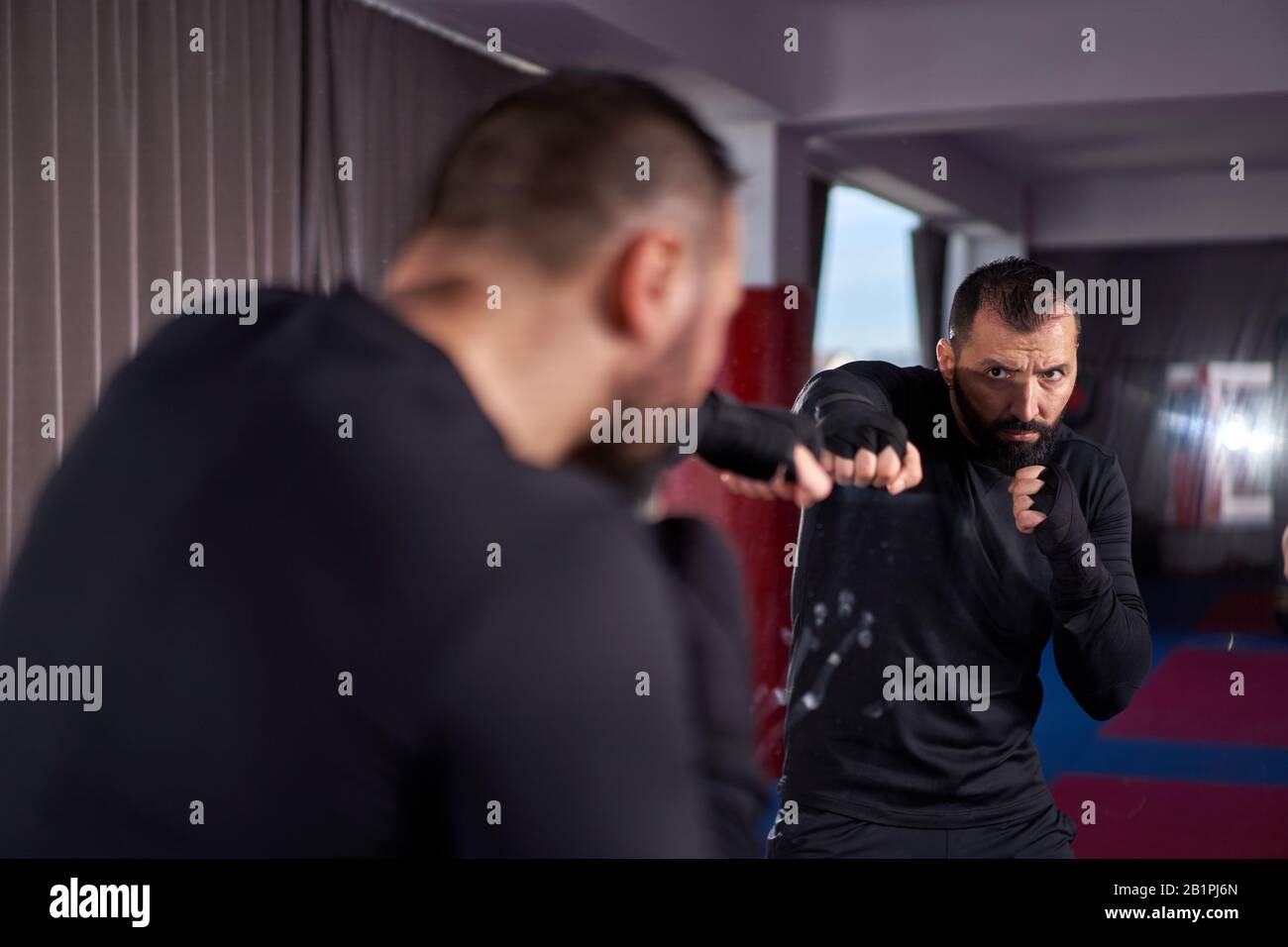 Fighter with hands wrapped shadow boxing in the mirror Stock Photo - Alamy