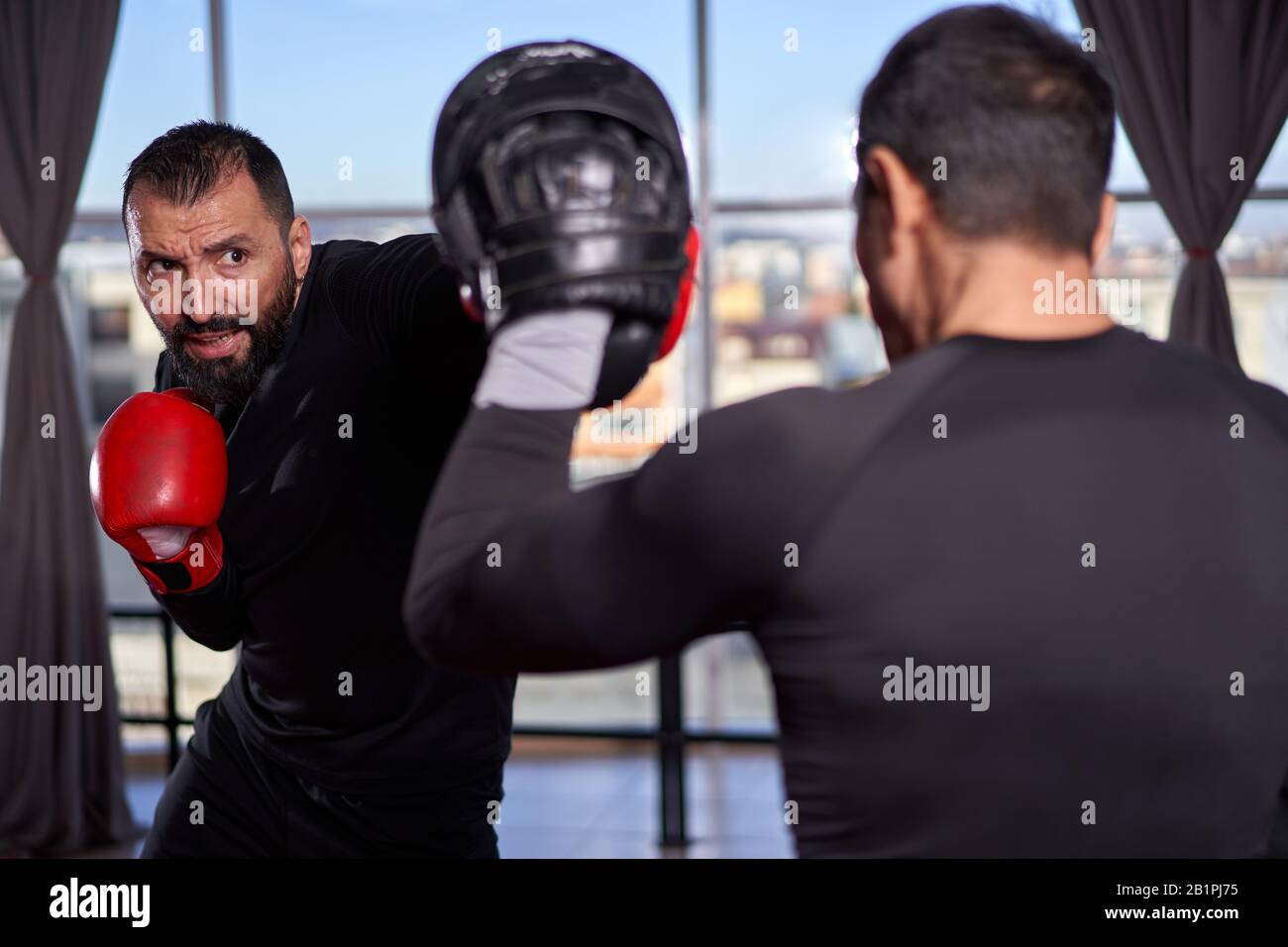 Boxer hitting mitts with his coach in the gym Stock Photo - Alamy