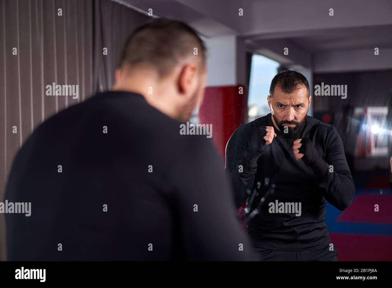 Fighter with hands wrapped shadow boxing in the mirror Stock Photo - Alamy