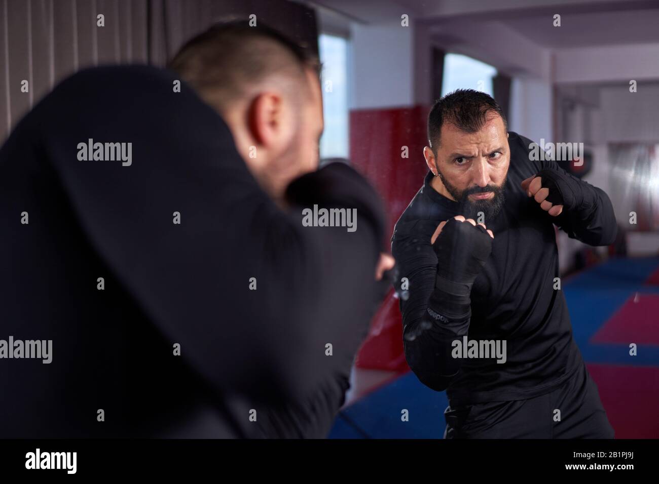 Fighter with hands wrapped shadow boxing in the mirror Stock Photo - Alamy