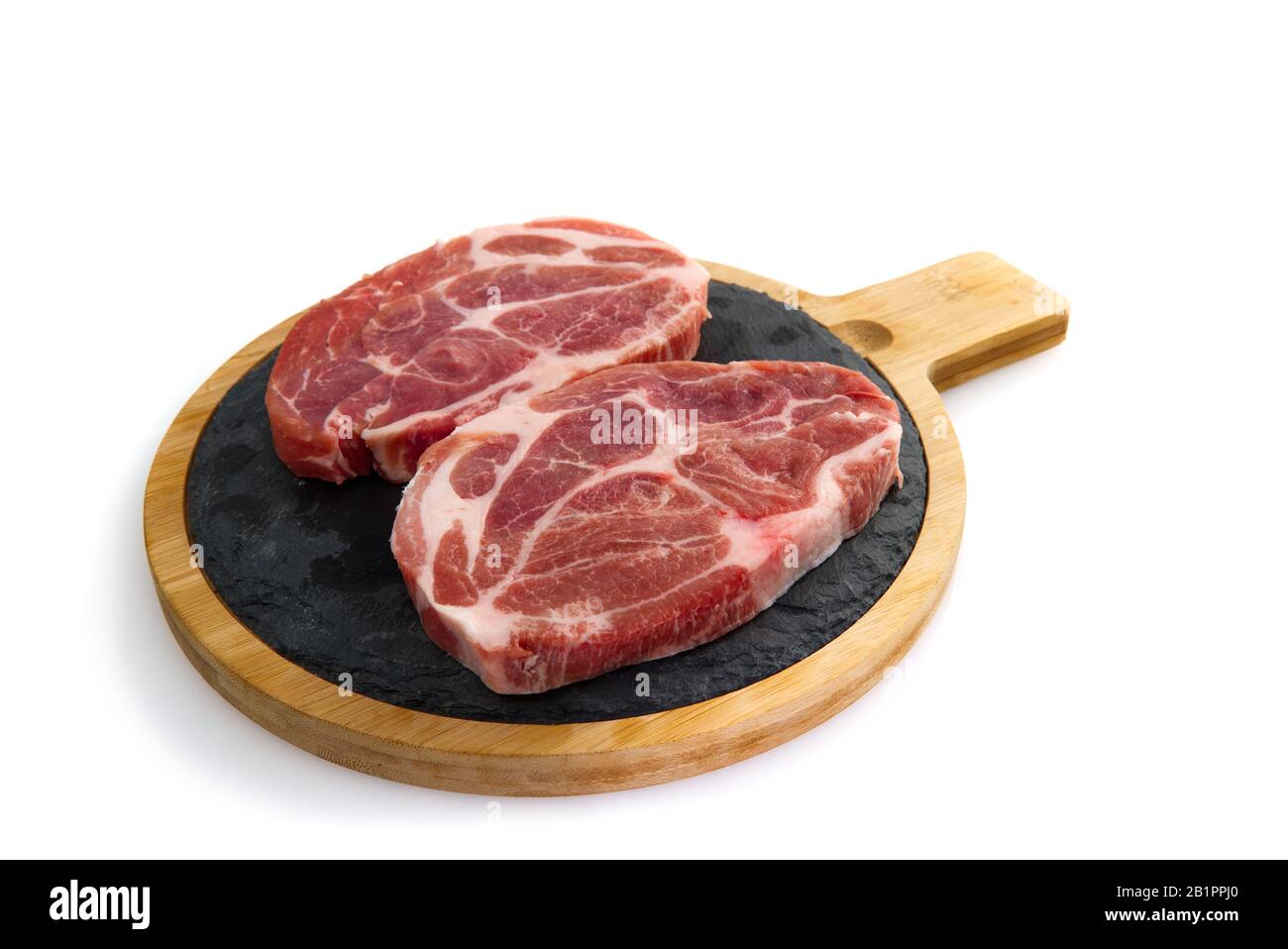 two raw pork slices on black stone plate, isolated on white Stock Photo ...