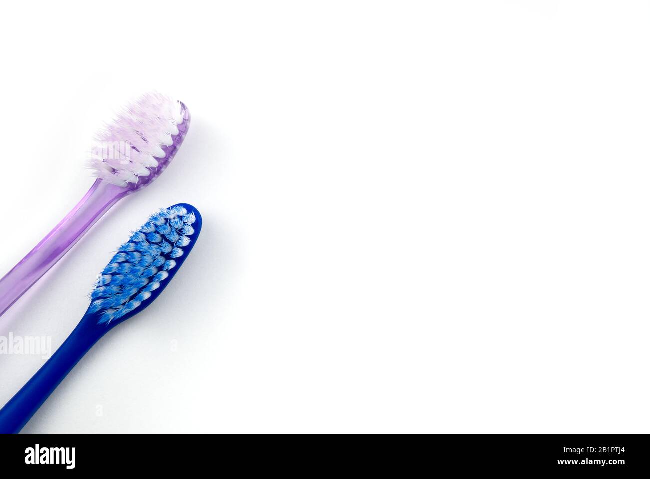 couple of pink and blue toothbrushes isolated over white background ...