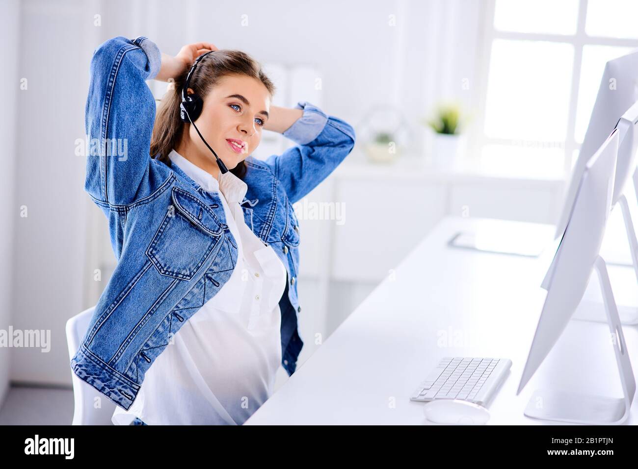 Tired female customer support operator in the office with headset Stock ...