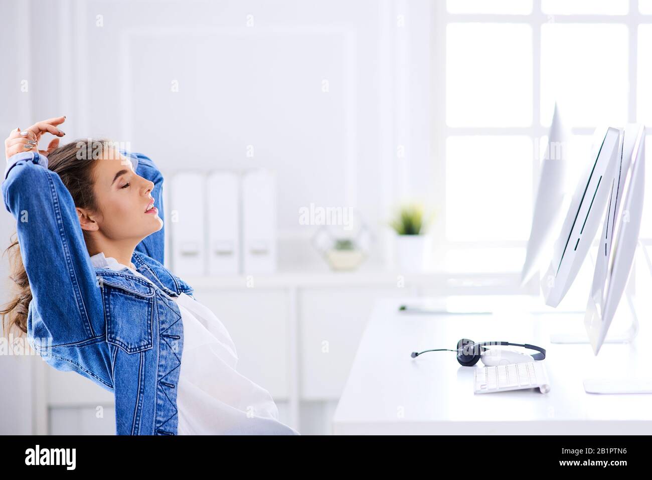 Young female customer support operator relax in the office with headset ...