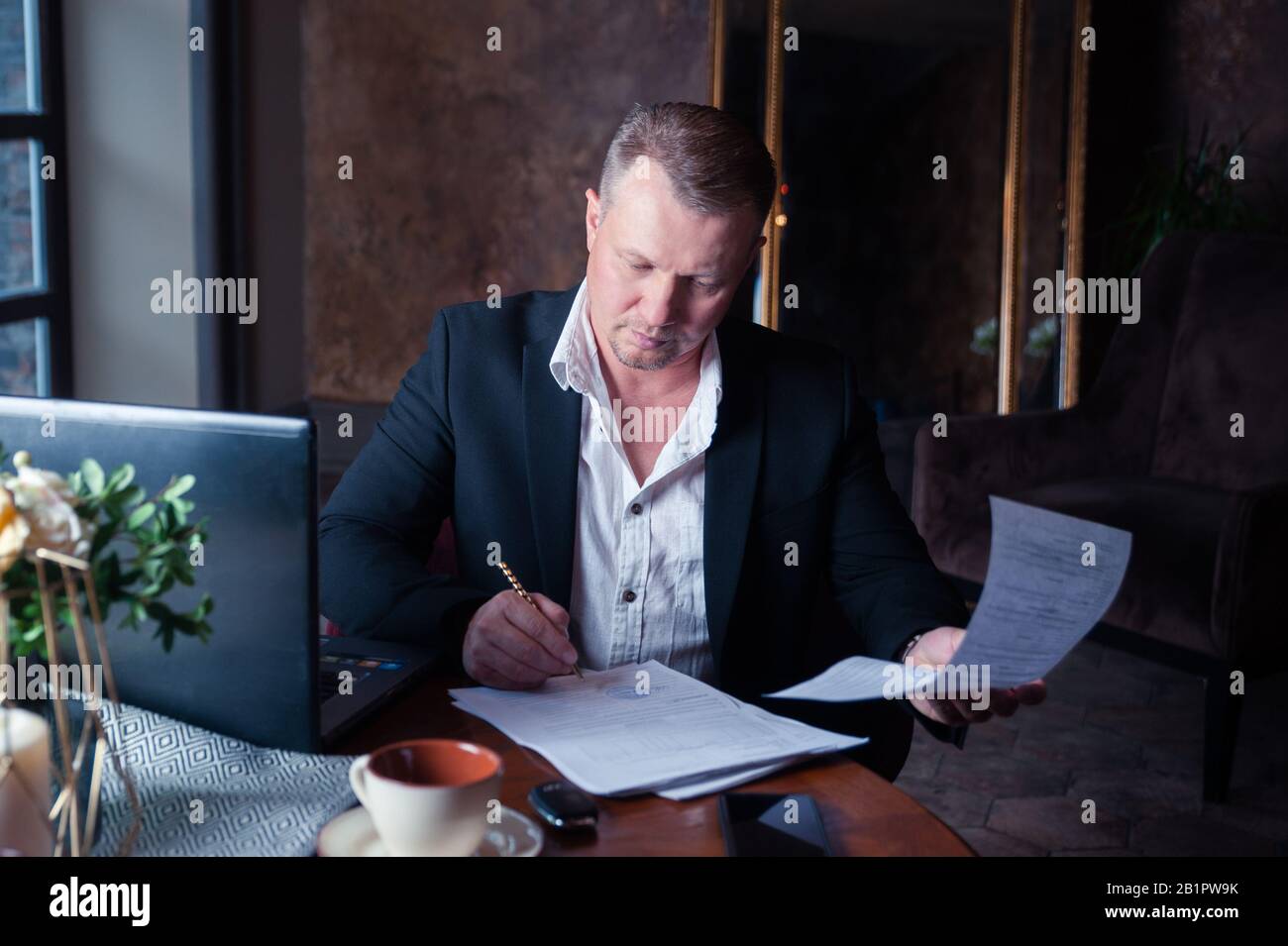 Elegant white man signs papers in luxury apartments Stock Photo - Alamy