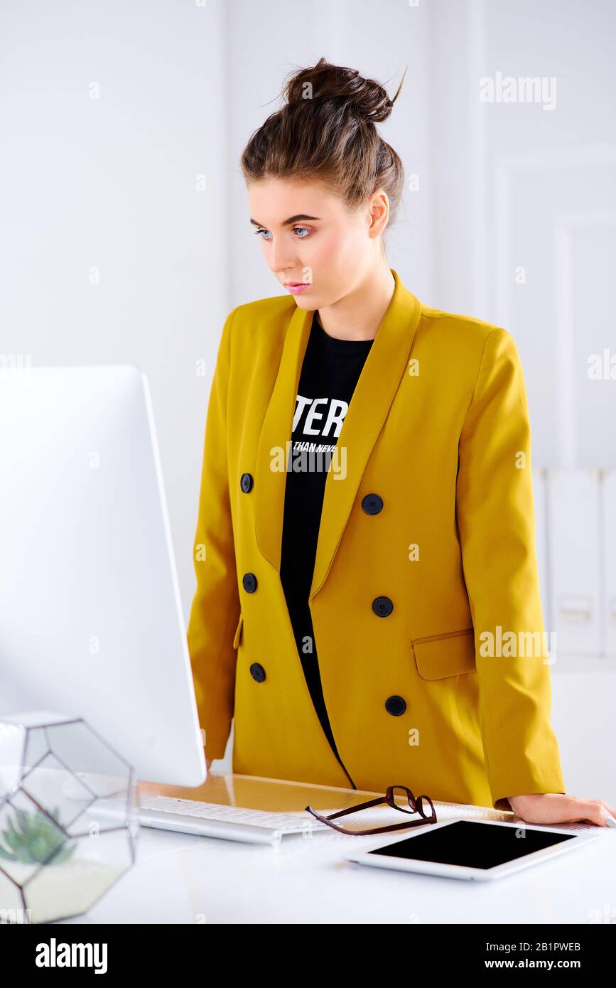 Young female designer in the office works at the computer ...