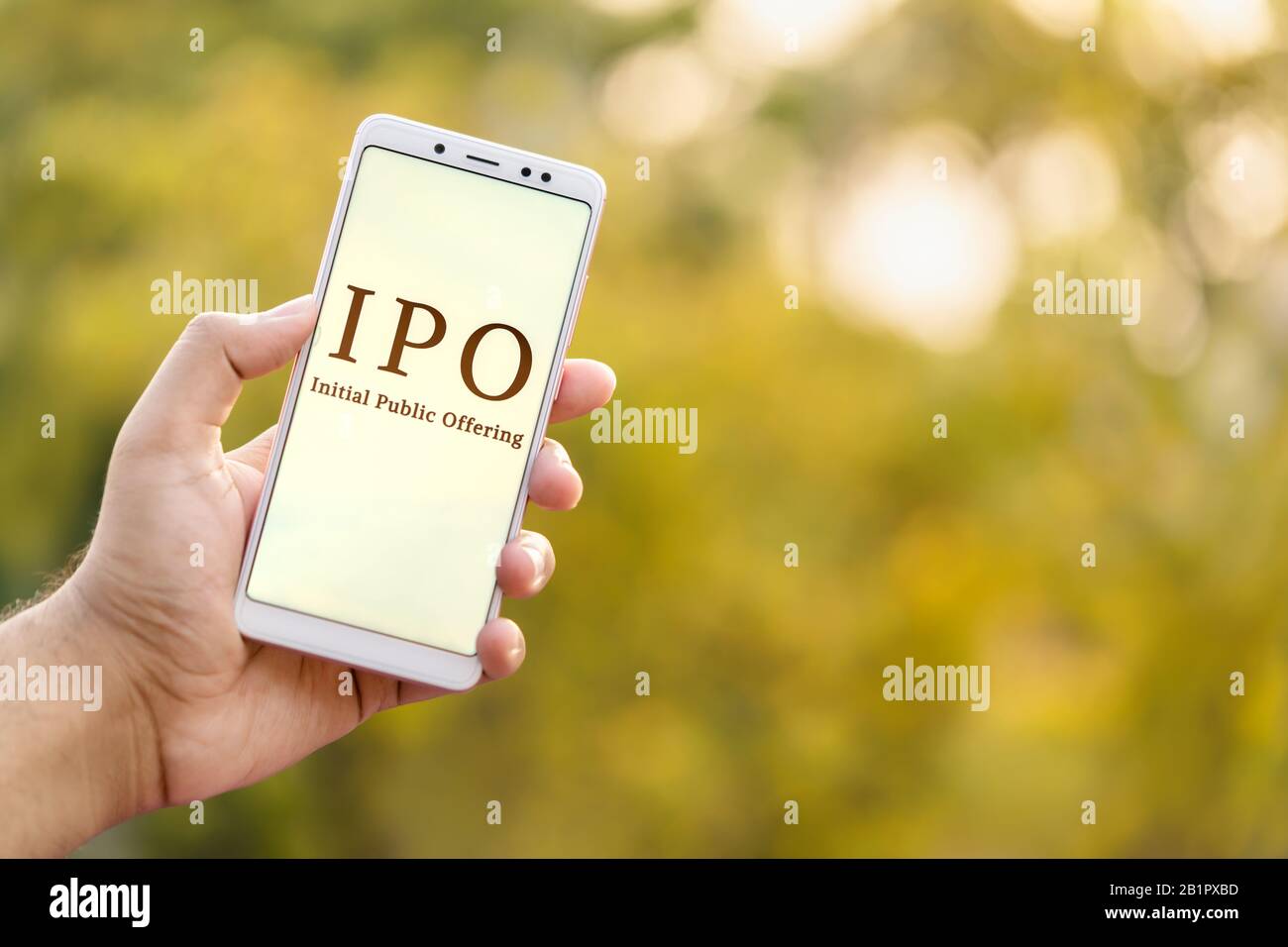 Initial Public Offering concept. Young male hand holding mobile phone ...