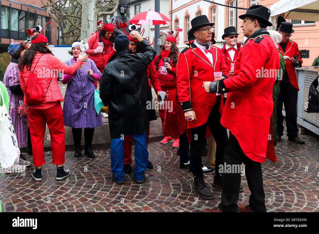 Spectators wear bright red costumes at the Rose Monday parade in Mainz ...