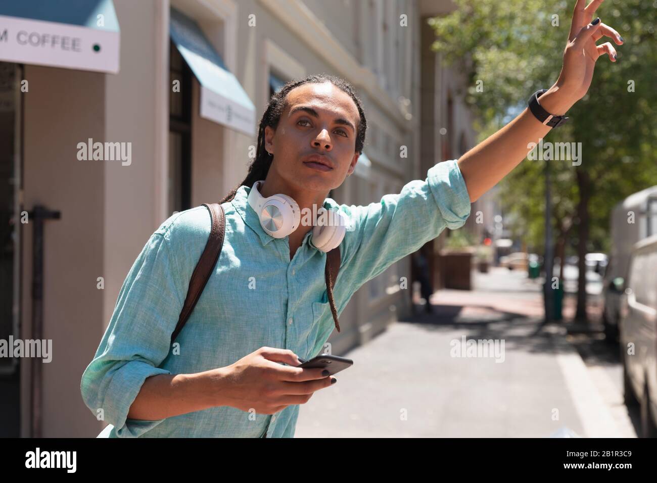 Mixed race man raising his hand Stock Photo - Alamy
