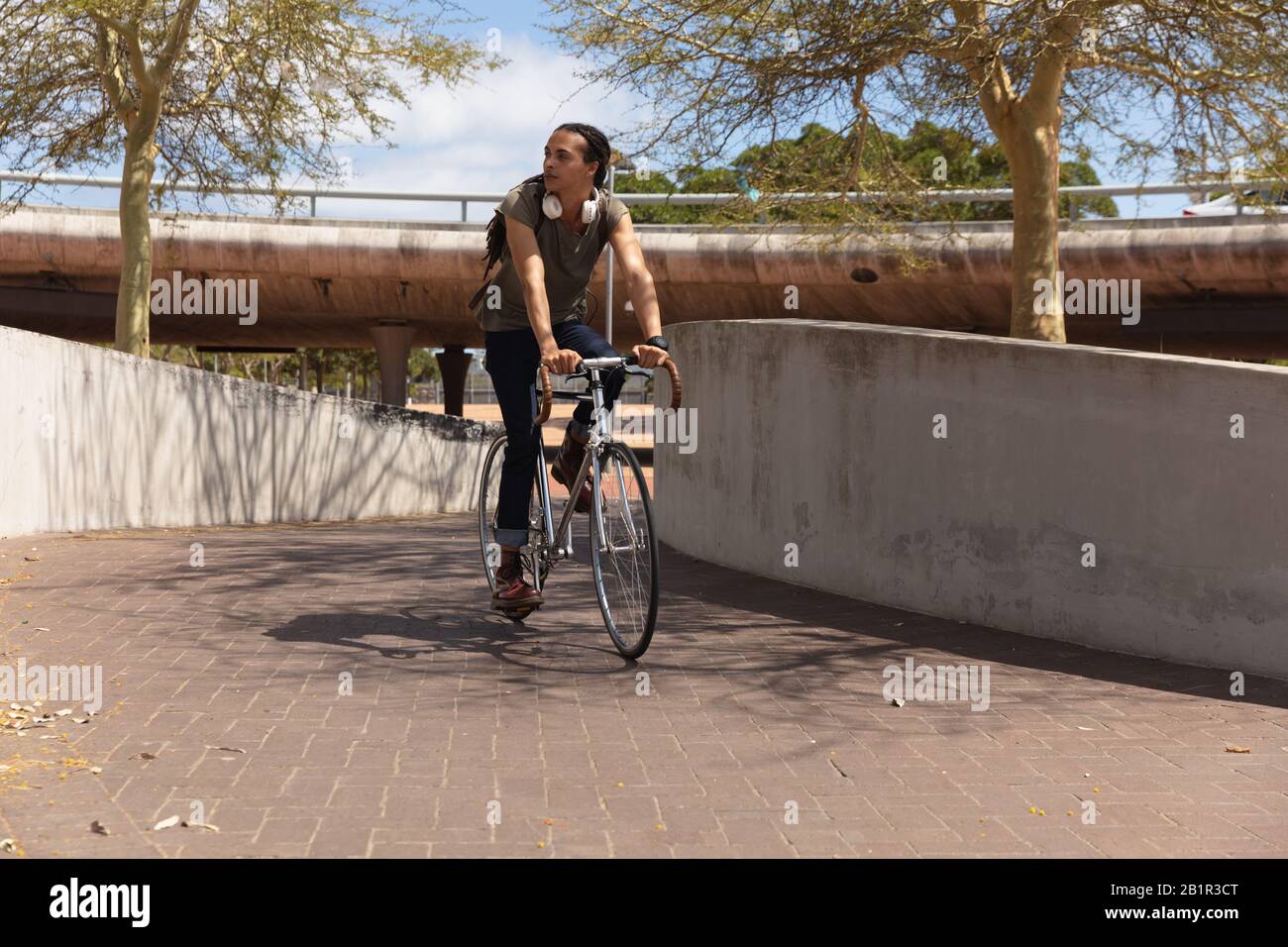 Mixed race man biking in the street Stock Photo - Alamy