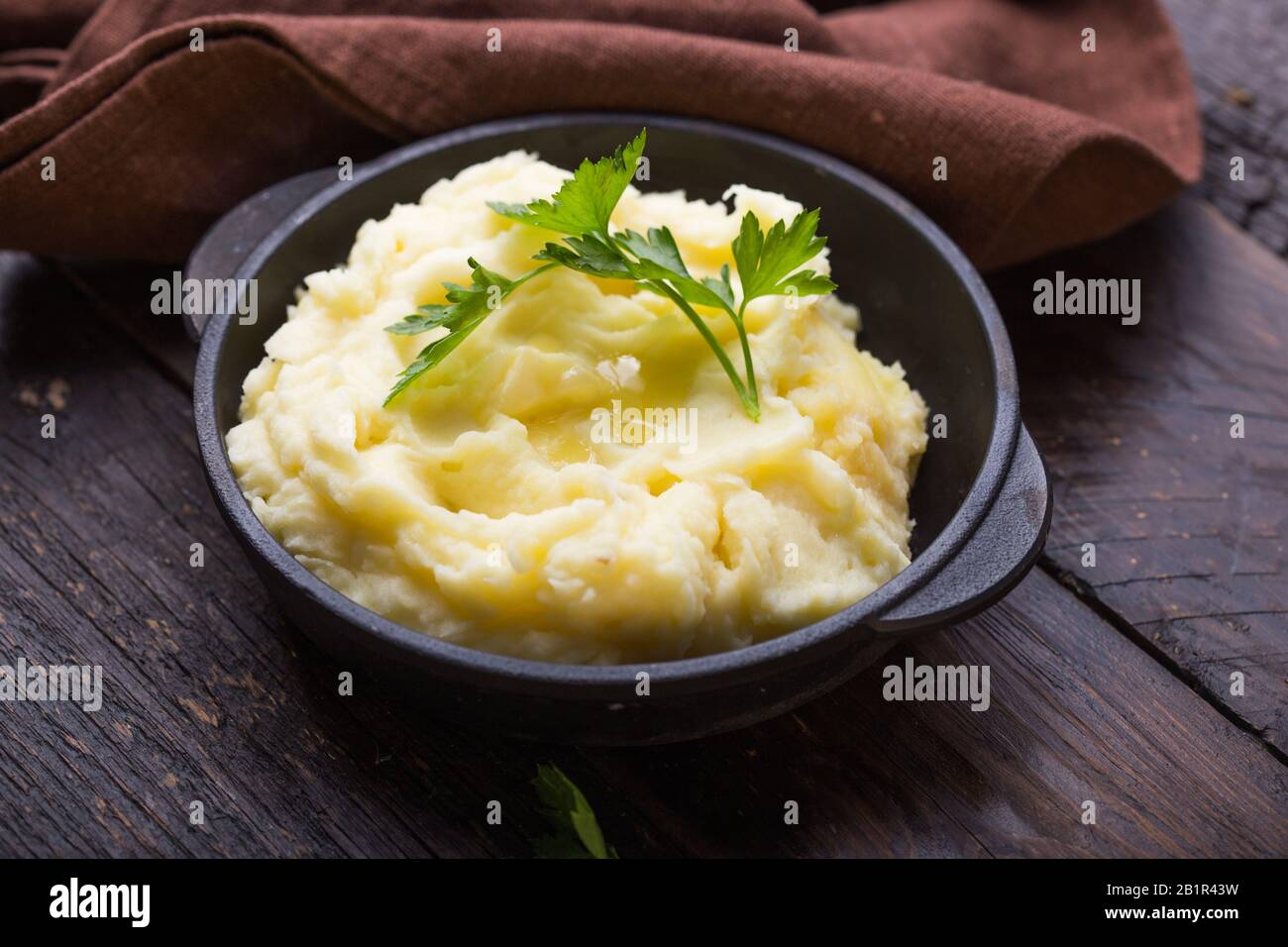 Mashed potatoes, boiled puree in cast iron pot on dark wooden rustic ...