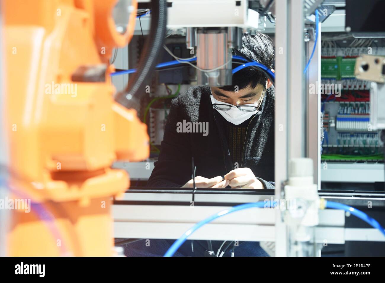 A Chinese engineer tests newly-manufactured robot arms at the plant of ...
