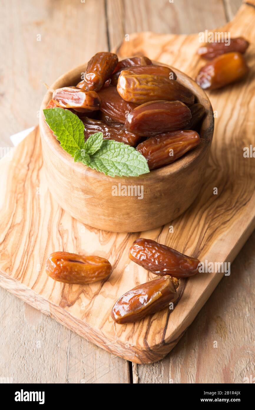 Dates palm fruit in wooden bowl is snack healthy Stock Photo - Alamy