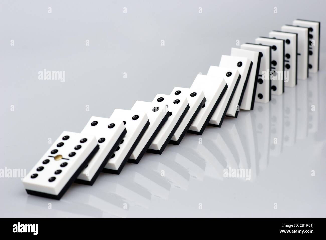 Dominos falling down in chain reaction Stock Photo - Alamy