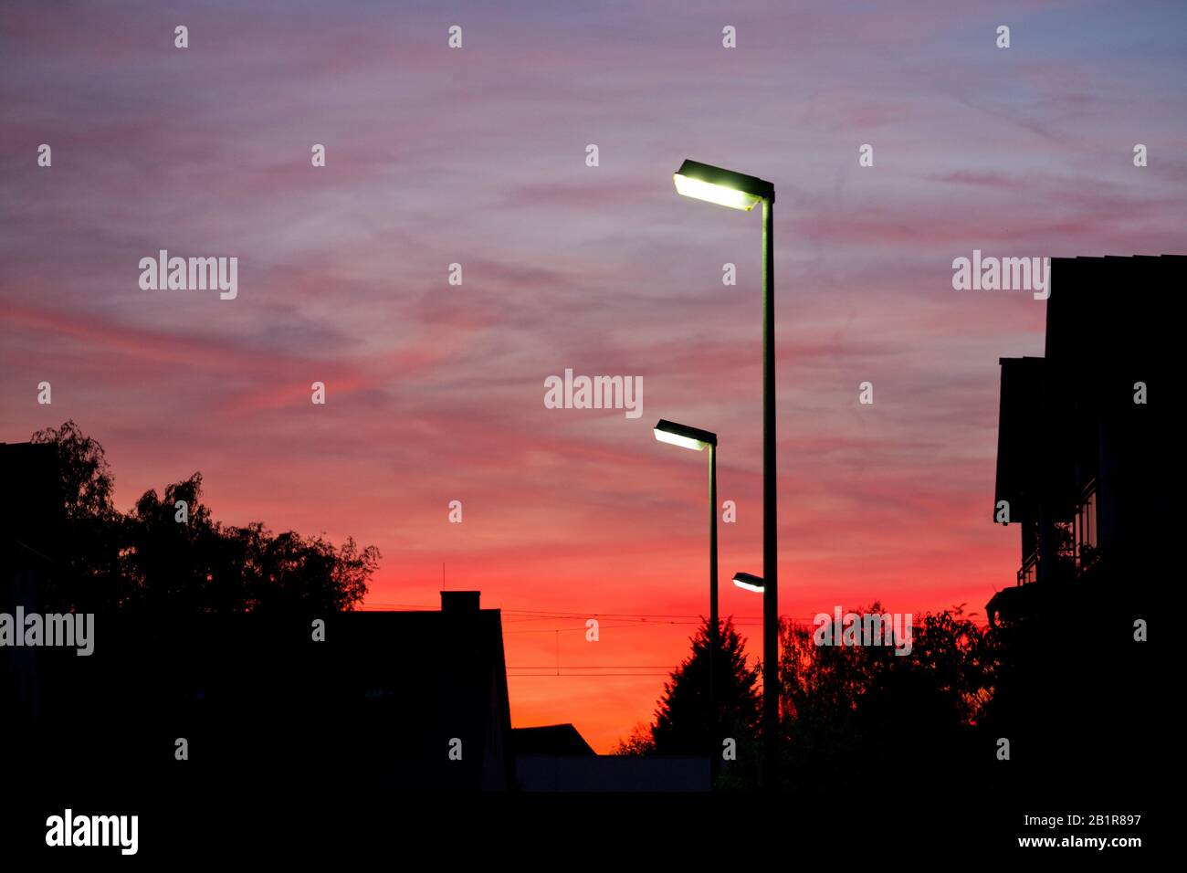 Illuminated street lights at dusk Stock Photo - Alamy