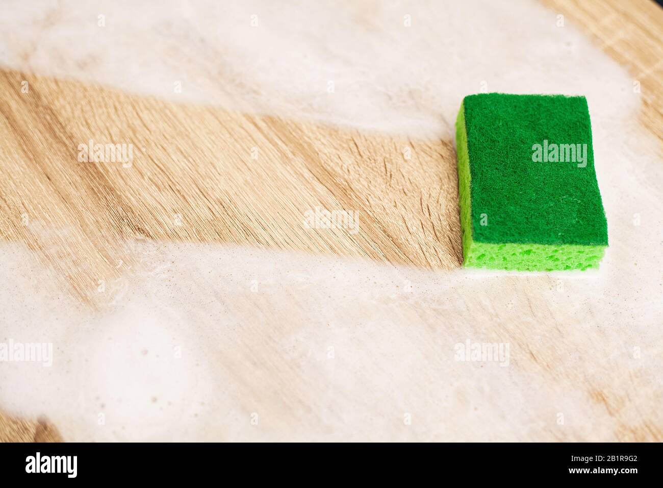 Employee using sponge for cleaning wood table Stock Photo - Alamy