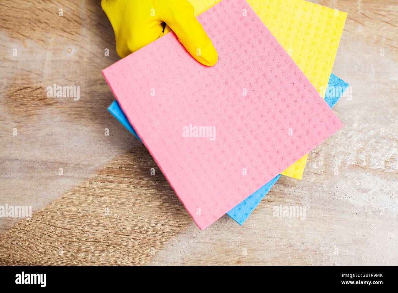Employee using sponge for cleaning wood table Stock Photo - Alamy