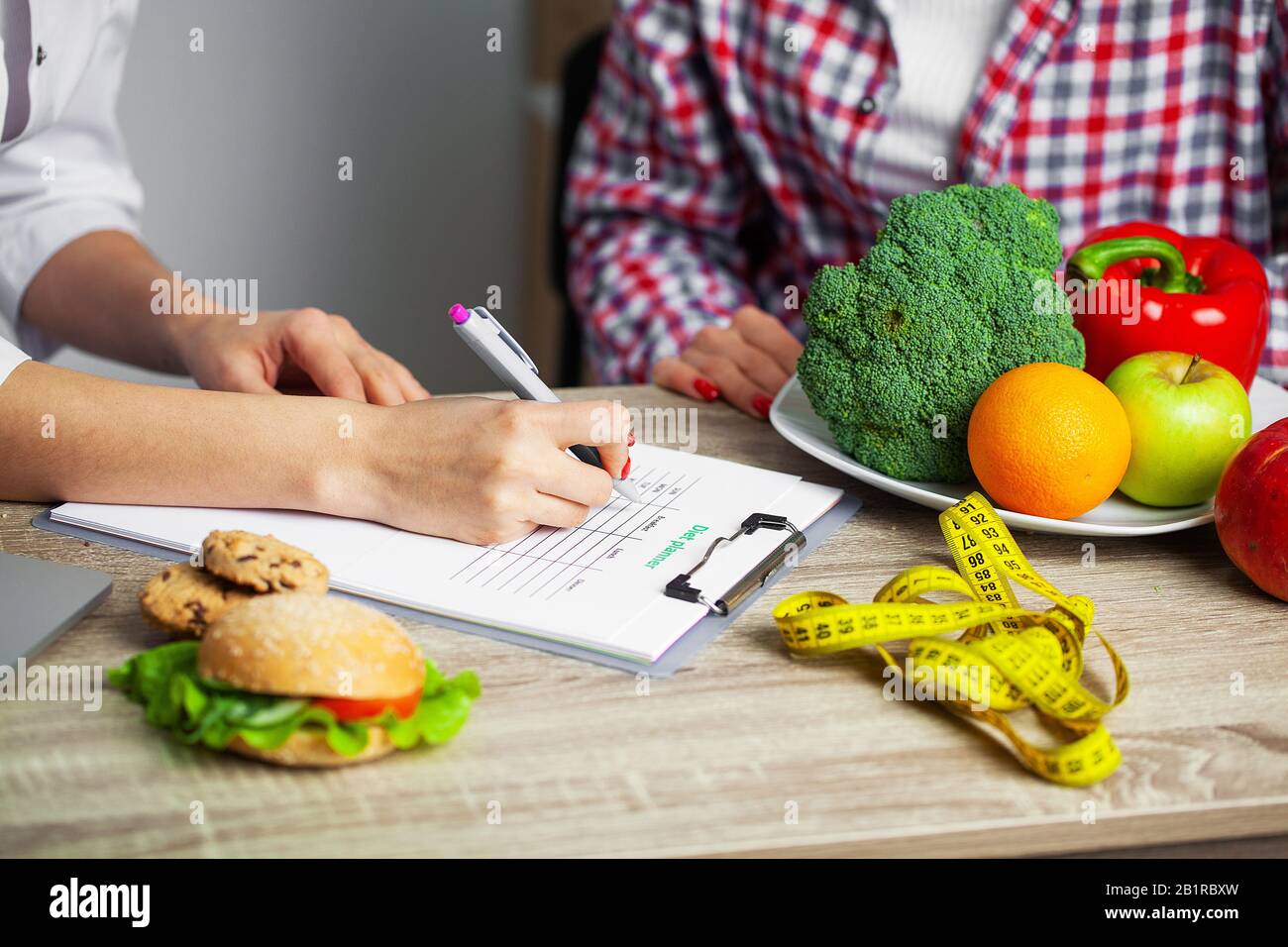 Nutritionist prepares a diet plan for an overweight woman Stock Photo ...