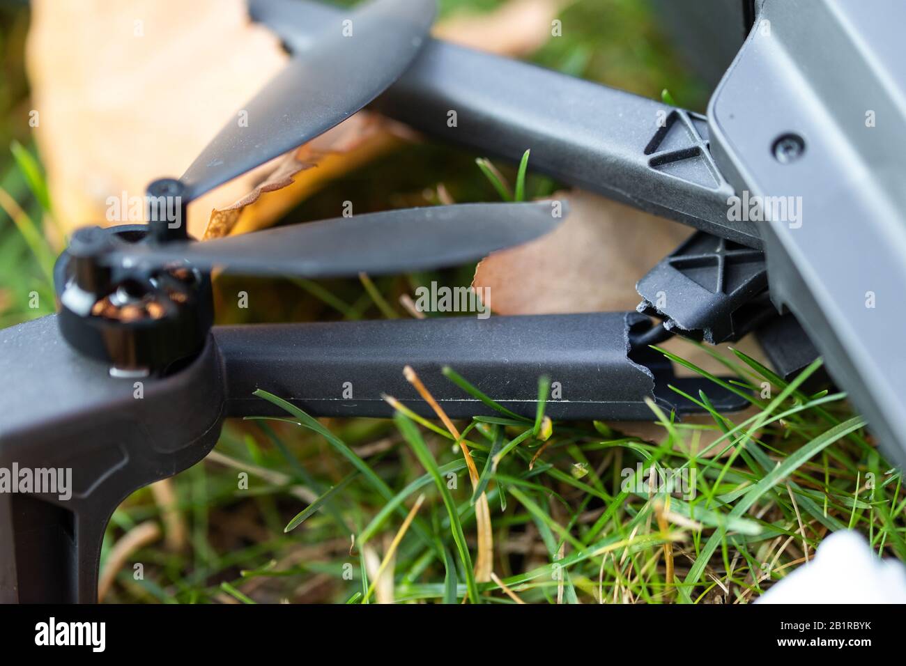 Broken black quadcopter drone uav lying on green grass lawn on ground ...