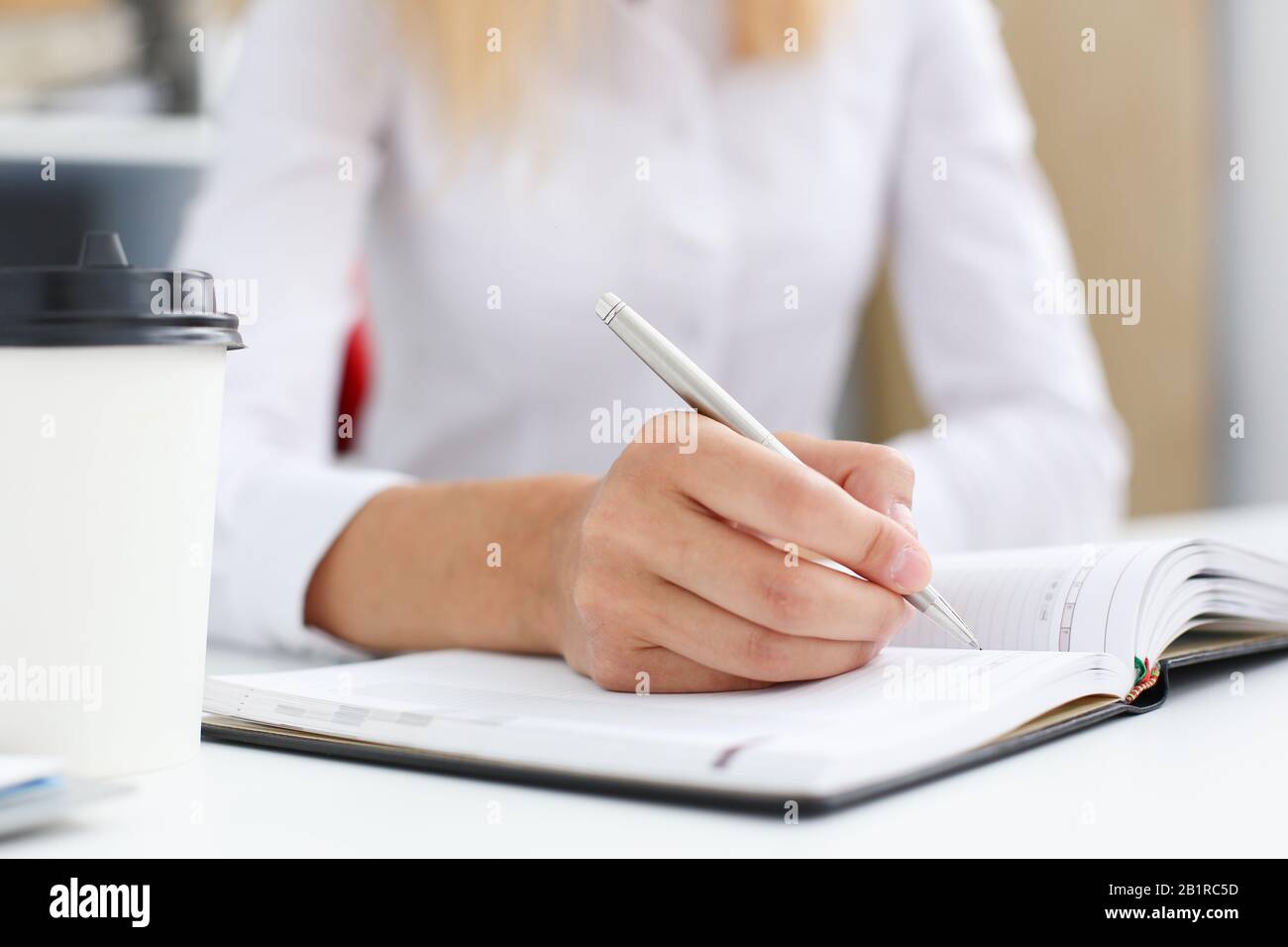 Female hand holding silver pen ready to make note Stock Photo - Alamy