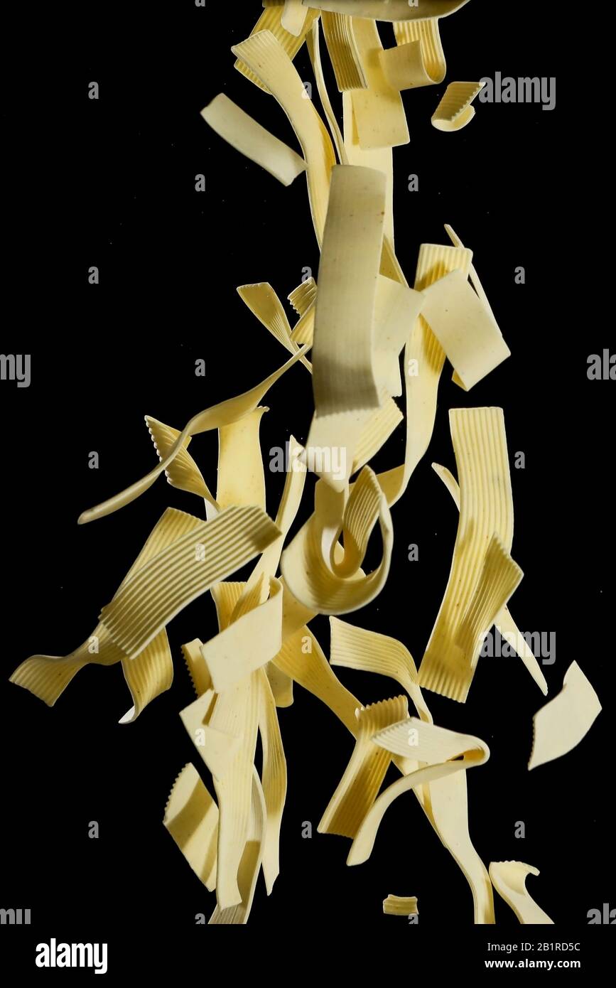 Falling pasta. Flying yellow raw macaroni over black background Stock ...