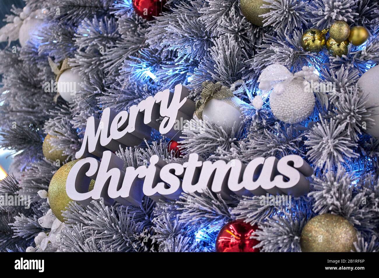 Christmas toys yellow and white on a branch of an artificial Christmas ...